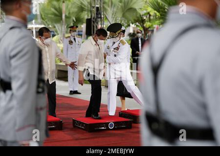 Philippine President Rodrigo Duterte is assisted as he removes his face ...