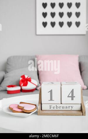 Calendar with date 14 FEBRUARY and cookies on table in living room ...