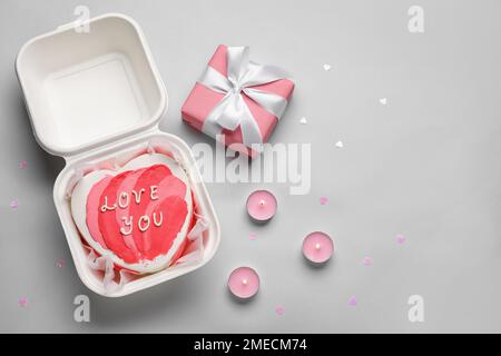Heart-shaped bento cake with gift boxes on white background. Valentine ...