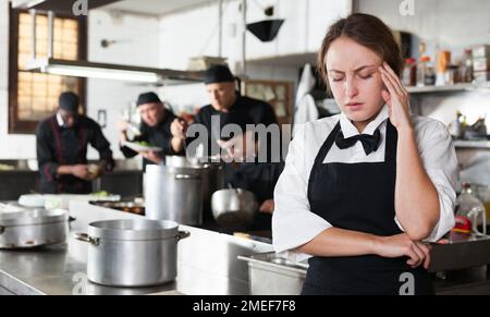 Tired and upset waitress in kitchen of restaurant Stock Photo - Alamy