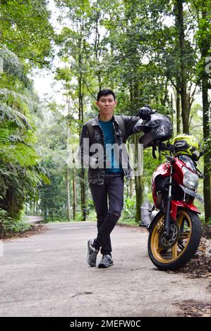 posing in front of a motorbike with a beautiful and cool view of the ...