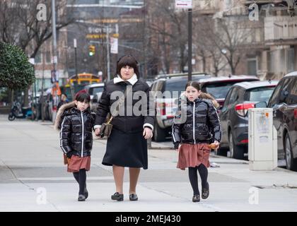 3 orthodox Jewish school girls walk home together wearing the same plaid skirt, their school's ...