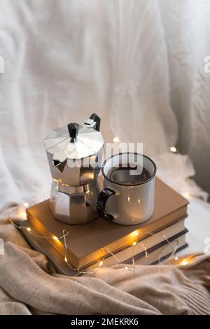 A moka pot end a cup of coffee in a cozy holiday environment. Enjoying ...