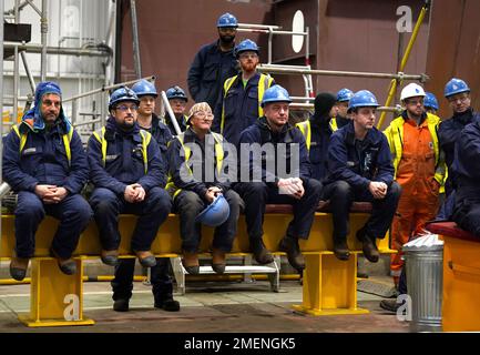Workers look on as the first cut of steel for the Royal Navy frigate ...