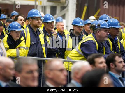 Workers look on as the first cut of steel for the Royal Navy frigate ...