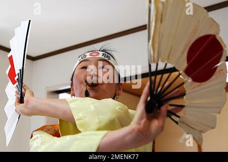 Olympic fan Kyoko Ishikawa shows an image on a TV screen showing her at ...