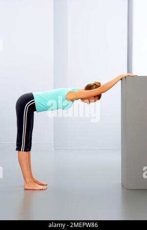 Side view of woman practicing yoga in the mountains. Female is ...