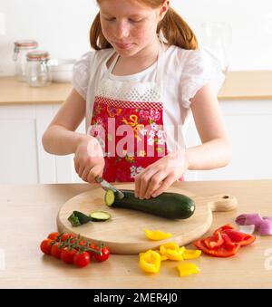 Girl chopping courgette, peppers and tomatoes, 9 years Stock Photo - Alamy
