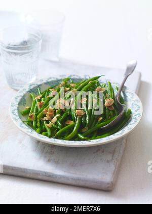 Cooked green beans with almonds in bowl on wooden table, top view Stock ...