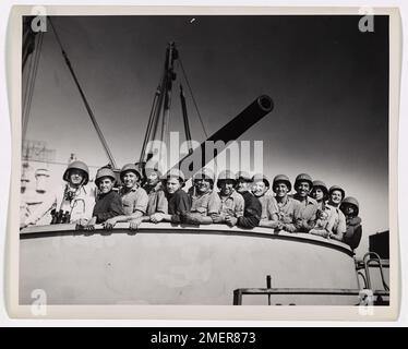 Coast Guardsmen aboard a transport ship are depicted holystoning the ...