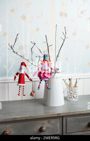 Paper fairy and Father Christmas decorations hanging from twigs Stock ...