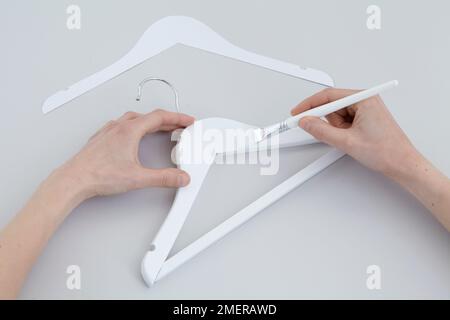 Close-up of hand applying glue to checked paper before glueing to ...