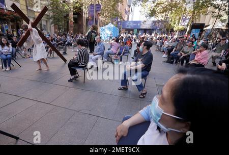 Actor Timothy Watkins carries a cross during his portrayal of Jesus ...