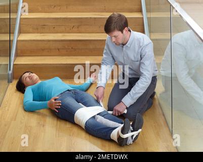 Woman, men and first aid with bandage, teaching or course with notes ...