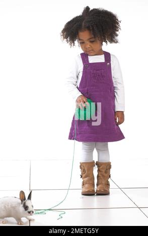 Girl standing holding ball of wool, 3 years Stock Photo - Alamy