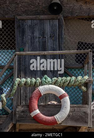 Lifeguard rescue float on wooden dock by calm lake water. Weekend ...