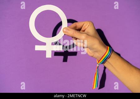 A woman holding a female symbol drawing, purple background, fighting in ...