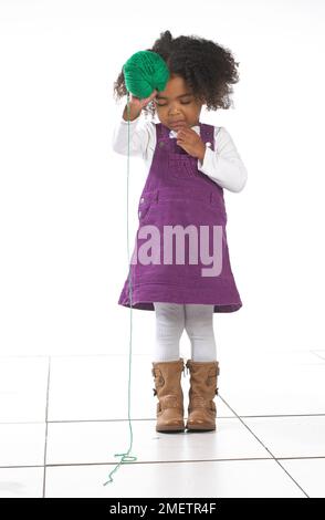 Girl standing holding ball of wool, 3 years Stock Photo - Alamy