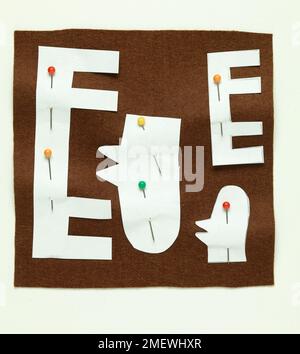 Cutting out heads, horns and feet for attaching to knitted sheep, using ...