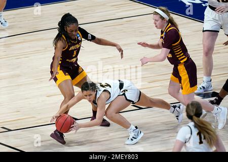 Iowa guard Gabbie Marshall, center, shoots over Nebraska forward ...