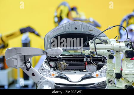 Industrial robotic working with automobile on blurred smart car factory ...