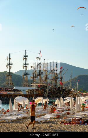 Beachgoers and pirate ship shaped tour boats in Belcekiz Beach ...