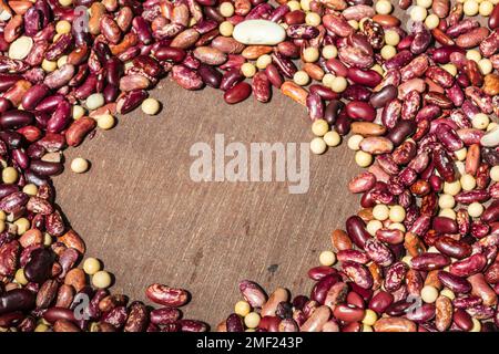 A closeup of a mixture of beans spilled on a wooden table Stock Photo ...