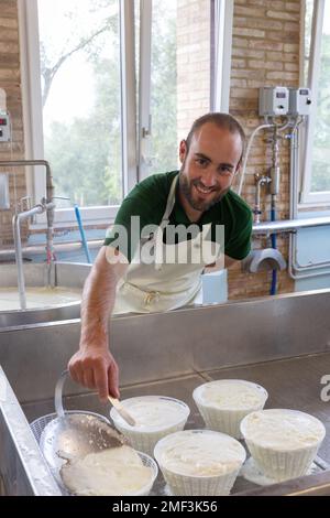 Man making cheese at Fior di Montalcino cheese farm in Tuscany, Italy ...