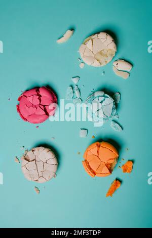 Crushed, broken macaron, French colored dessert on a blue background ...