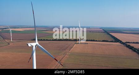 Wind turbines on flat terrain. Panorama. Green energy. Use of renewable ...
