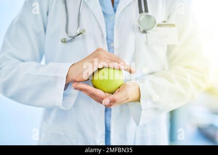 Cropped hands of doctor holding fresh orange with measuring tape for ...