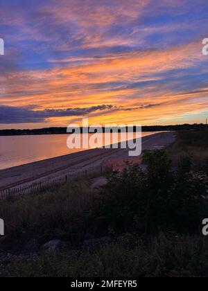 A vertical shot of a sandy beach the against sea at sunset in the ...