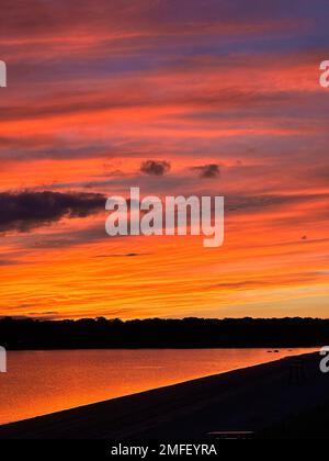 A vertical shot of a sandy beach the against sea at sunset in the ...