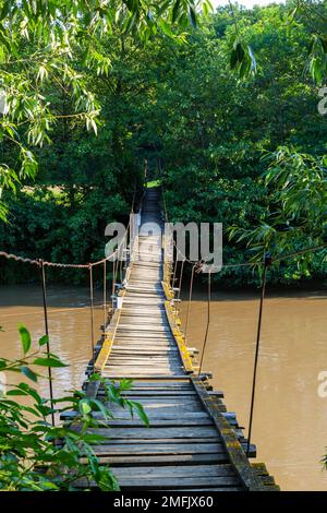 Suspended wooden bridge to the other side of the river. Suspension ...