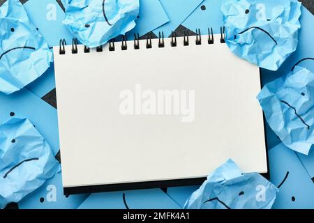 Blue crumpled sticky notes blank with drawing sad face on black ...