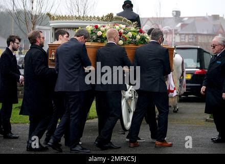 The bearer party, including father Tim Edwards (right) lift the coffin ...
