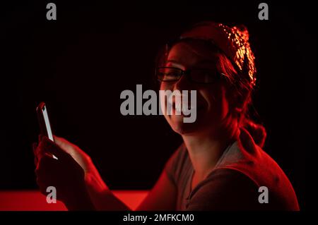 Paranoid caucasian woman using smartphone wearing tinfoil hat ...