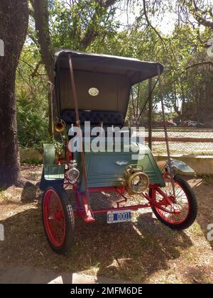 Antique green 1902 Rambler Model D Runabout roadster in a park. Nature ...