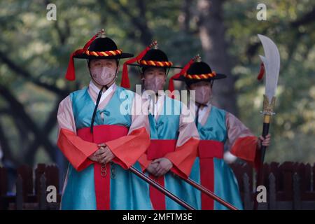 Performers wearing traditional guard uniforms and protective face masks ...