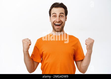 Image of enthusiastic adult man winning, celebrating victory, smiling ...