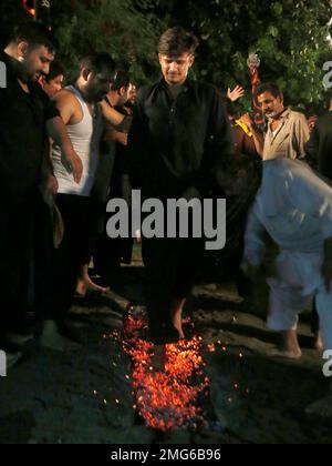 A Pakistani Shiite Muslim walks on burning coal as a religious ritual ...