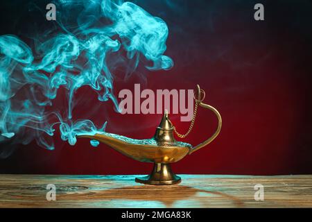 Aladdin lamp of wishes with smoke for Ramadan on table against dark ...