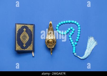 Aladdin lamp of wishes, Koran and prayer beads for Ramadan on blue ...