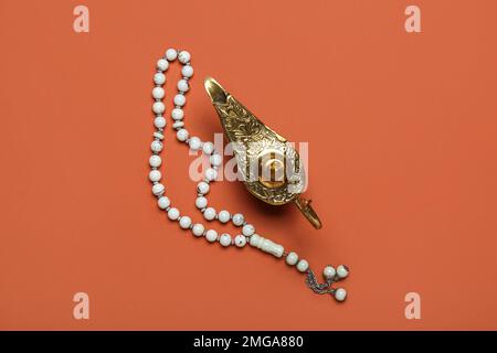Aladdin lamp of wishes and prayer beads for Ramadan on dark background ...