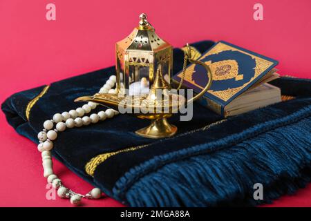 Aladdin lamp, Muslim lantern, Koran and prayer beads for Ramadan on mat ...