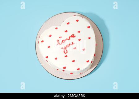 Plate with heart-shaped bento cake and envelope on grey background ...