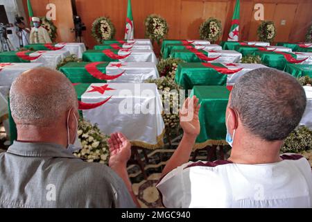 Men pray by coffins of the 24 Algerians at the Moufdi-Zakaria culture ...