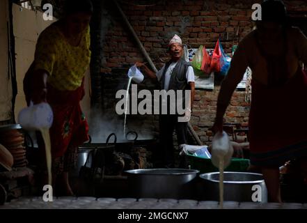 A traditional Nepalese yogurt maker boils milk to prepare yogurt during ...