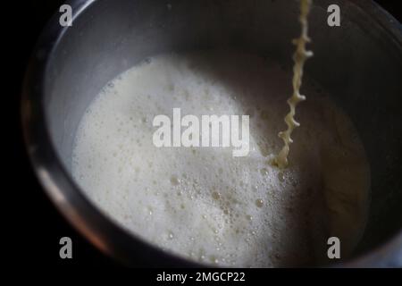A traditional Nepalese yogurt maker boils milk to prepare yogurt during ...