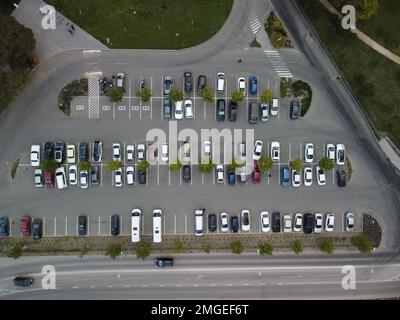 Busy large modern carpark with symmetrical roads rows of parking bays ...